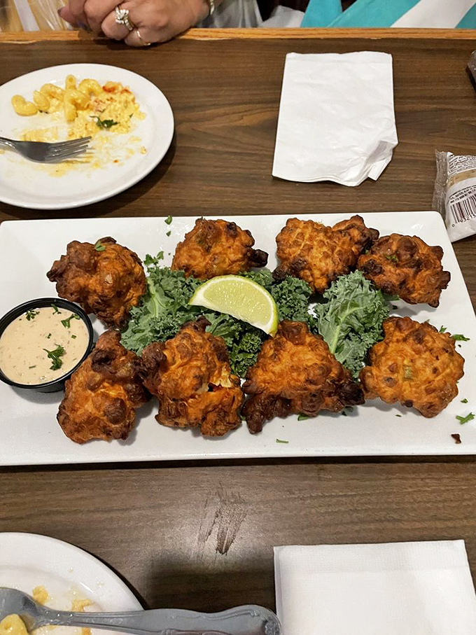 These conch fritters aren't just fried dough balls&mdash;they're golden-brown Caribbean postcards, crispy on the outside, tender within, begging to be dipped in that sauce.