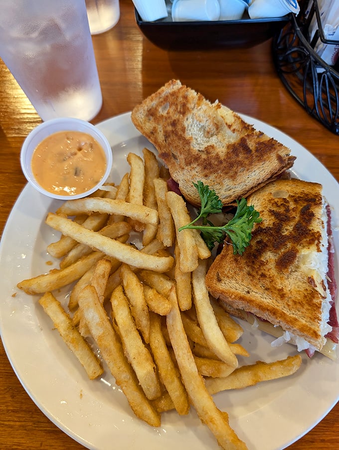 This sandwich isn't just grilled—it's been transformed into a golden-brown promise of happiness, escorted by fries that demand to be dunked.