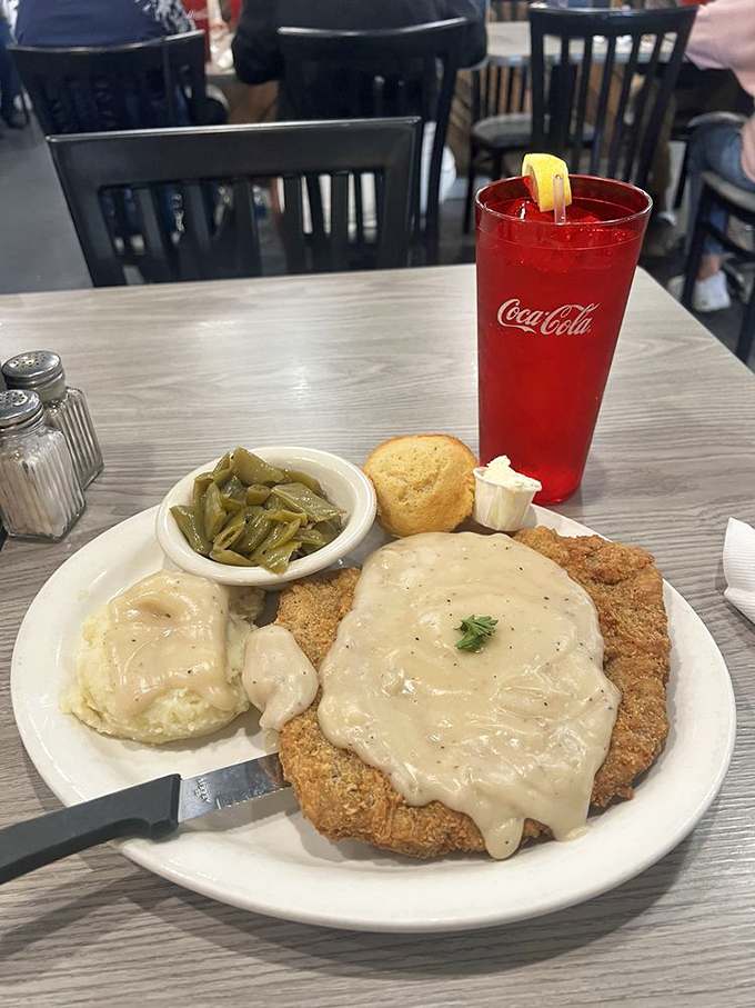 Country fried steak that doesn't know it's 2023. That gravy blanket, those mashed potatoes, and green beans straight from someone's garden&mdash;comfort defined.