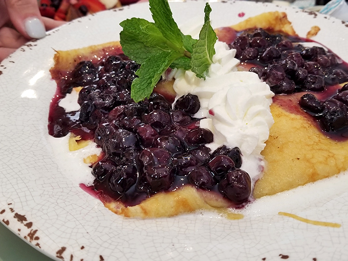 Blueberry crepes that make you question why you ever settled for cereal. That mint garnish isn't just for show&mdash;it's the exclamation point on a breakfast statement.