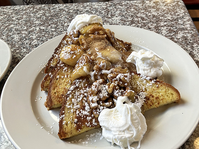 French toast that's dressed for success! Golden brioche crowned with caramelized apples, whipped cream, and a sprinkle of powdered sugar perfection.