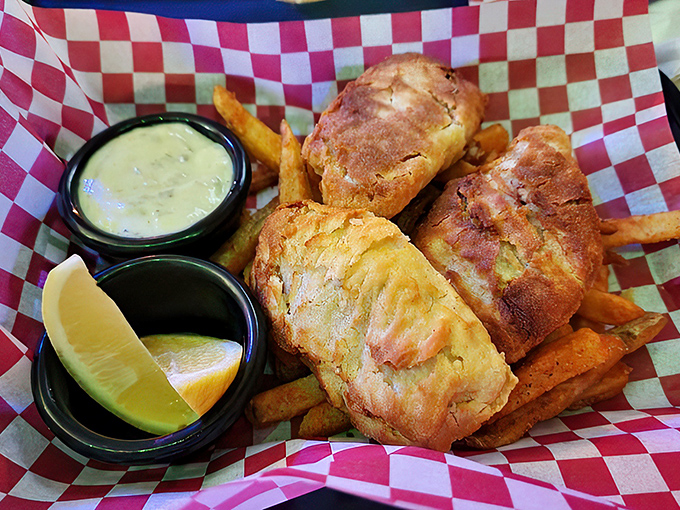 Golden-battered fish chunks nestled among perfectly crisp fries, served with house-made tartar sauce. The red and white checkered paper says "casual," but the flavor screams "sophisticated."