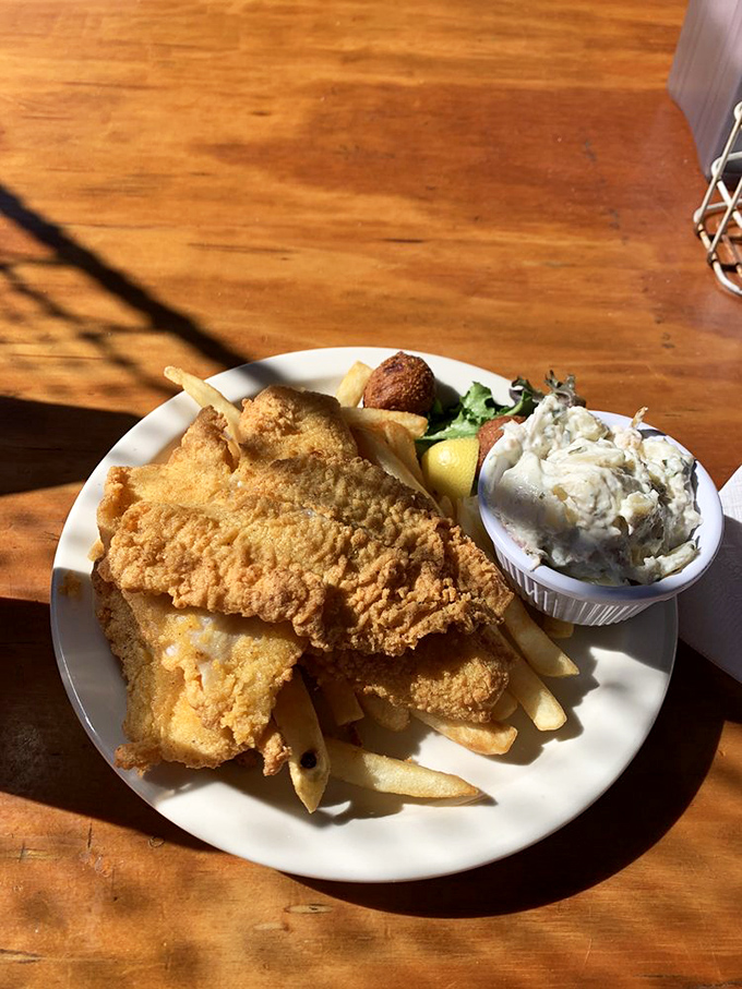 Golden-battered fish resting on a bed of hand-cut fries with a side of homemade coleslaw&mdash;the kind of plate that makes conversation stop mid-sentence.