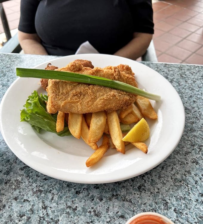 Golden-battered fish perched atop a mountain of fries&mdash;this isn't just fish and chips, it's edible architecture that crackles with each bite.