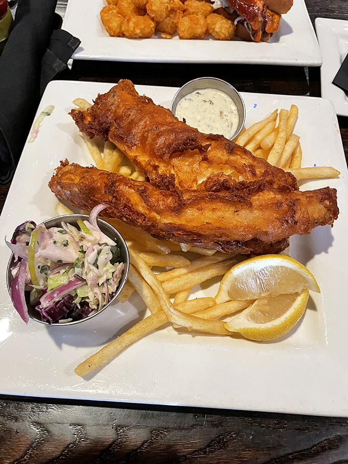 Golden-battered fish that shatters like glass with each bite, nestled among fries that clearly never met a freezer. This is fish and chips done right.