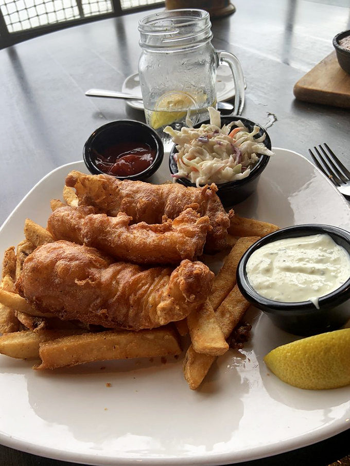 Golden-battered fish perched atop crispy fries&mdash;this isn't just fish and chips, it's edible architecture with a side of nostalgia and tartar sauce.