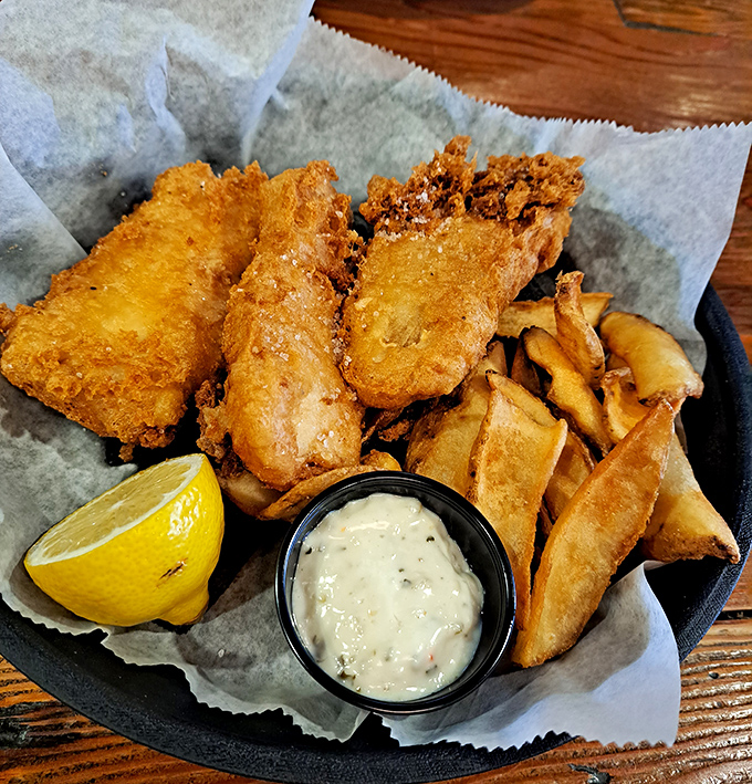 Golden-battered fish that shatters with each bite, paired with chips that could make a potato farmer weep with pride. This is edible poetry.
