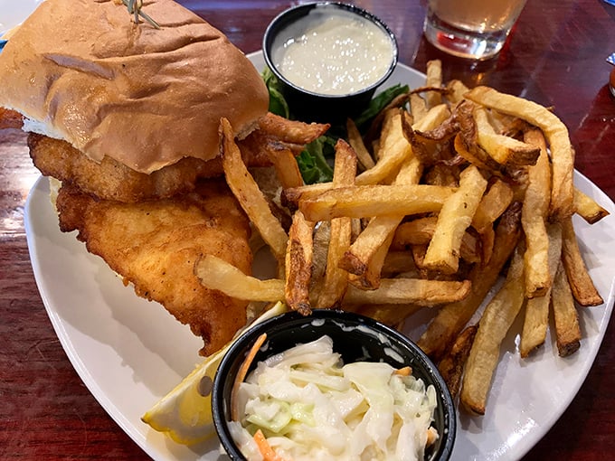 The fish sandwich that launched a thousand return visits – golden-battered perfection nestled in a pillowy bun with hand-cut fries that demand equal attention.