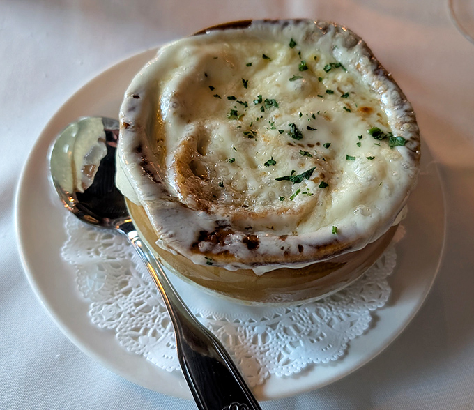 Behold, the French onion soup that launched a thousand sighs—a bubbling cauldron of caramelized dreams under a golden cheese canopy.