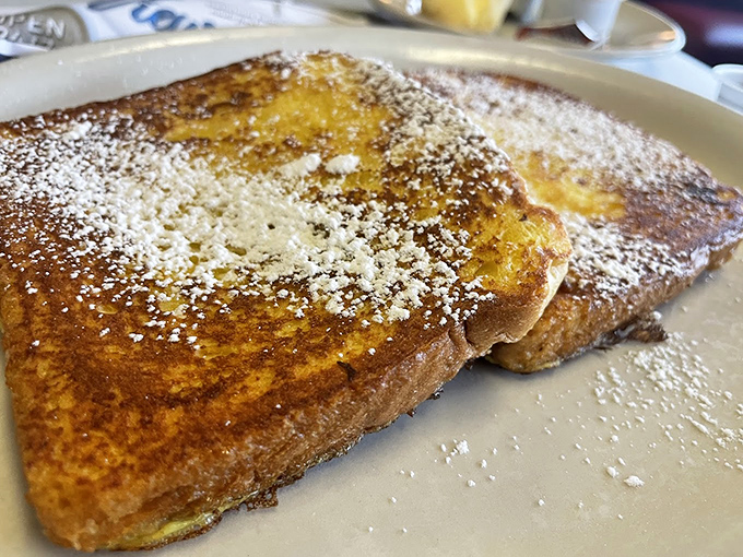 French toast that's achieved golden-brown perfection, dusted with powdered sugar like the first snow of winter. Breakfast alchemy at its finest.