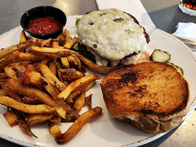 Behold: the burger in its natural habitat, surrounded by those legendary French fries. This plate doesn't need Instagram filters to look magnificent.