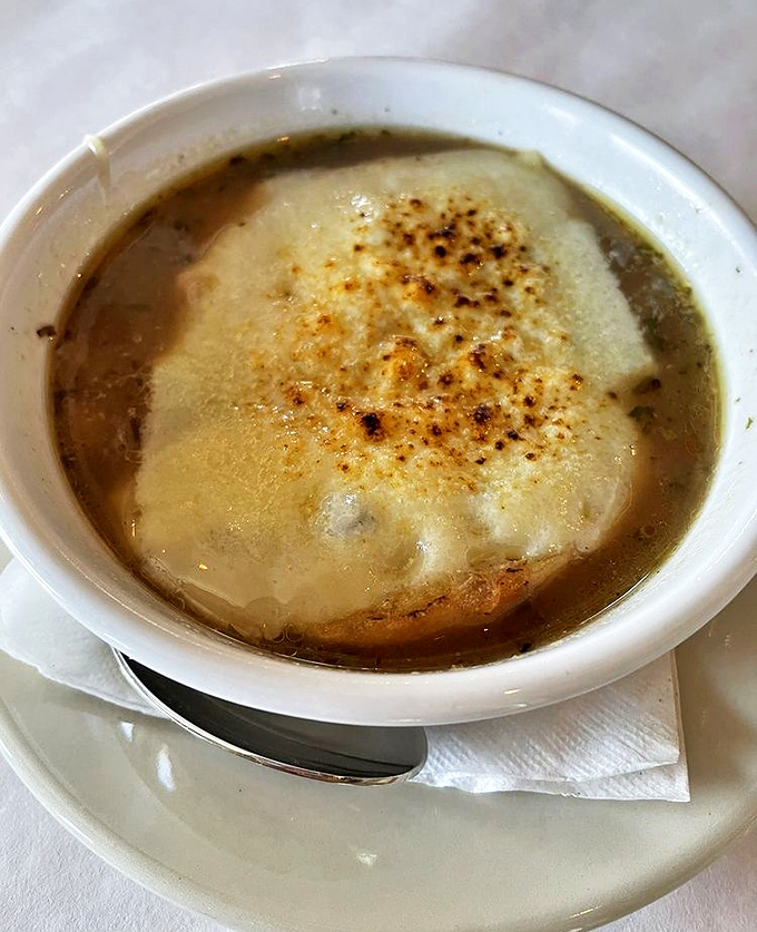 The legendary French onion soup arrives like a warm hug in a bowl, with cheese that performs an Olympic-worthy stretch with every spoonful.