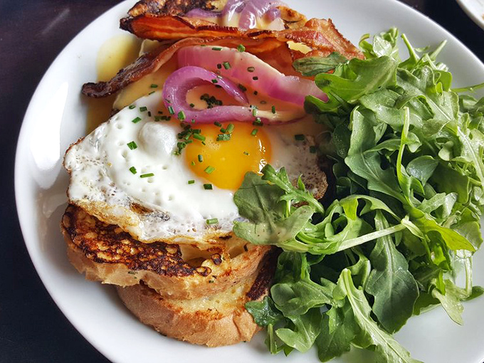 Breakfast architecture at its finest: crispy toast foundation, perfectly runny egg roof, and a garden of greens for curb appeal.