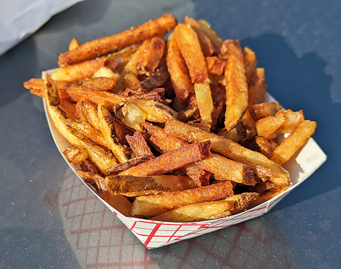 Golden-brown perfection in a paper basket. These hand-cut fries aren't just cooked; they're transformed into crunchy, potato-y works of art worth crossing state lines for.
