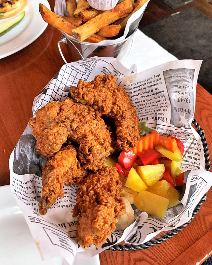 Golden-brown fried chicken that shatters at first bite, revealing juicy meat beneath&mdash;served with colorful pickled vegetables that cut through the richness perfectly.