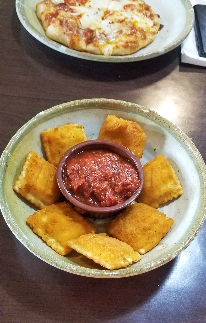 These golden-fried ravioli squares aren't just appetizers &ndash; they're little pillows of happiness that make waiting for your pizza an event rather than a chore.