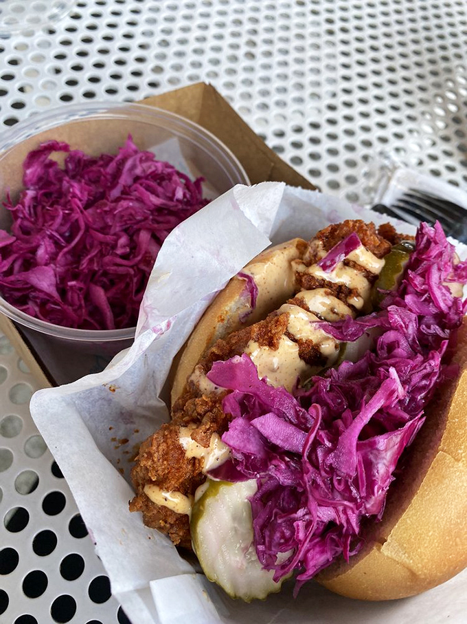 A symphony of textures&mdash;crunchy coating, juicy chicken, vibrant slaw, and tangy pickles&mdash;all nestled in a pillowy bun.