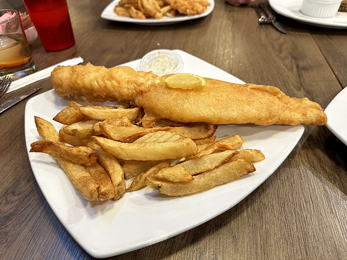 Golden-battered haddock resting on a bed of proper chips—this isn't just dinner, it's edible sunshine that crunches with each heavenly bite.
