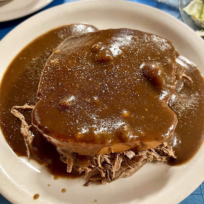 This hot roast beef sandwich isn't trying to impress food critics—it's too busy making regular folks swoon with its rich gravy bath.