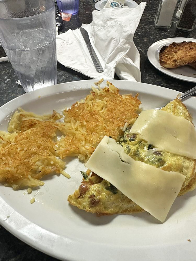 An omelet that doesn't need fancy ingredients to impress, just perfectly executed basics and those gloriously crispy hash browns.