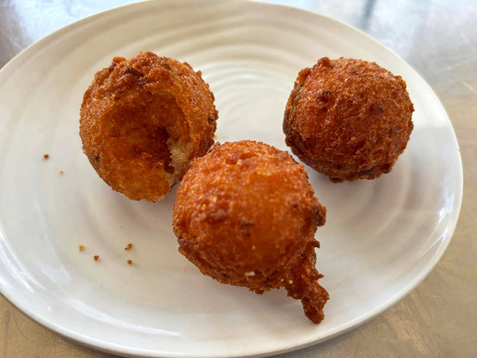 Golden-fried hush puppies that crunch like a satisfying whisper. The South's perfect appetizer ambassador has arrived at your table.