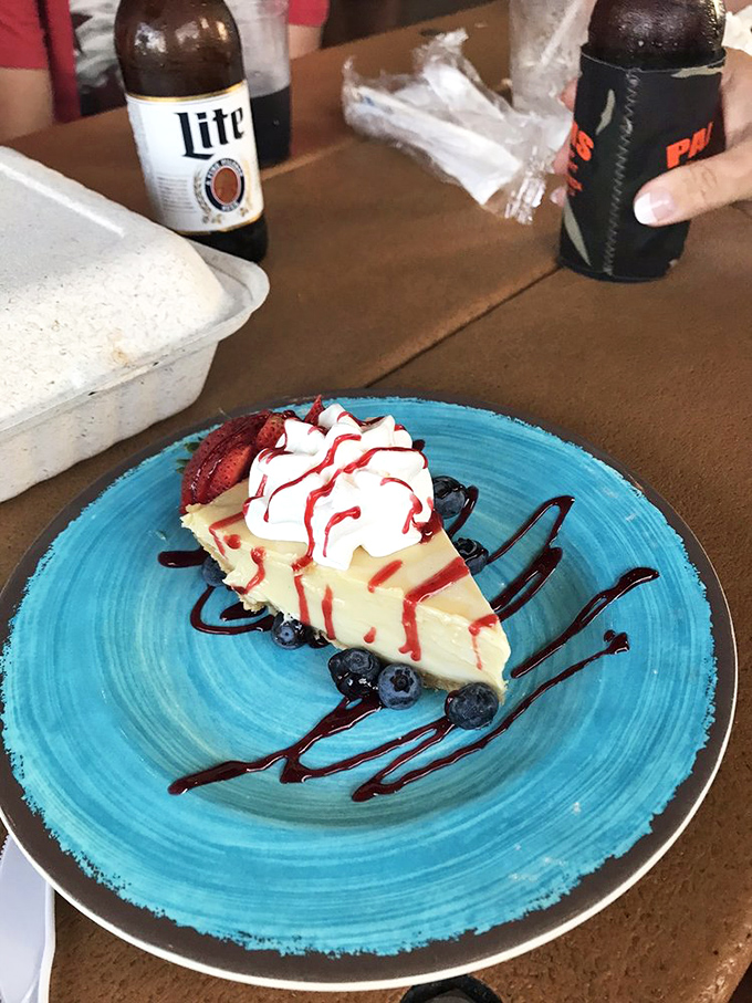 Key lime pie that strikes the perfect balance between sweet and tart, topped with whipped cream and served on a plate as blue as the Florida sky.