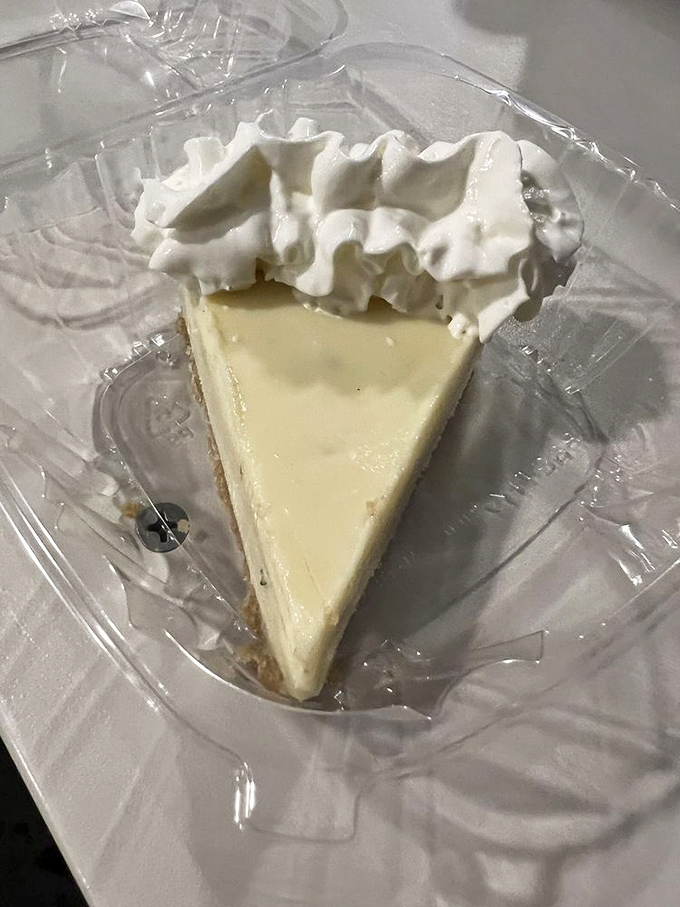 Key lime pie perfection—pale yellow filling (never green!) with a cloud of real whipped cream. This slice is the Florida Keys on a plate.