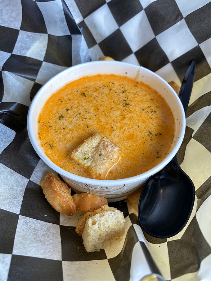 Liquid gold in a paper cup. This lobster bisque doesn't just warm your stomach&mdash;it hugs your soul with creamy, briny perfection.
