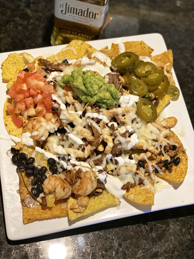 Behold the nacho mothership! Layers of melty cheese, black beans, shrimp, and perfectly placed jalape&ntilde;os create an architectural masterpiece worth demolishing.
