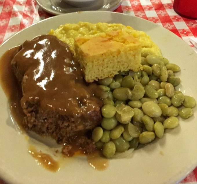 Behold the star attraction: meatloaf bathed in rich gravy alongside cornbread and lima beans&mdash;a plate that could make a vegetarian reconsider their life choices.