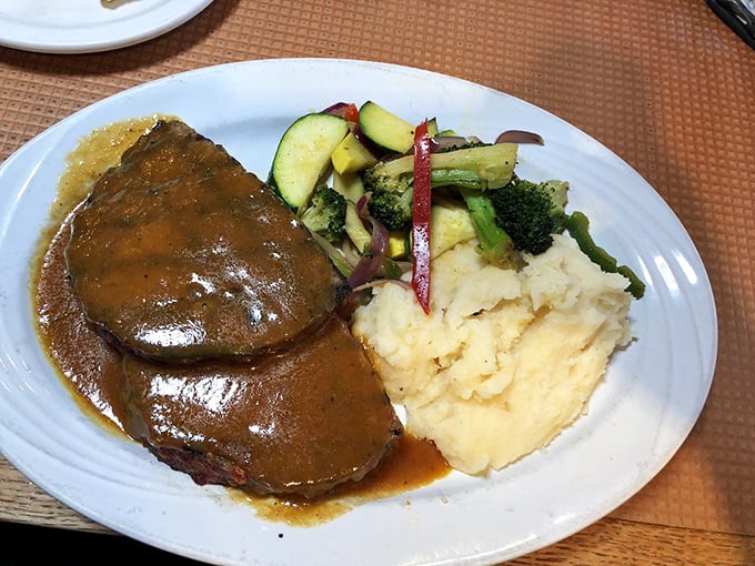 Behold the star attraction: meatloaf that doesn't just sit on the plate&mdash;it commands respect, swimming in gravy that should win Olympic medals.