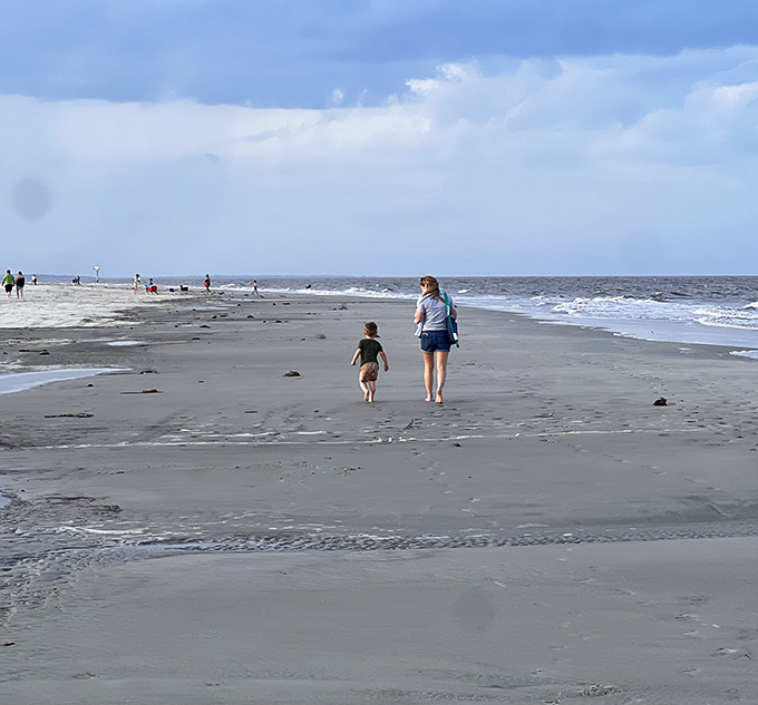 Generations connect along the shoreline as visitors discover the simple joy of a beach stroll away from digital distractions.