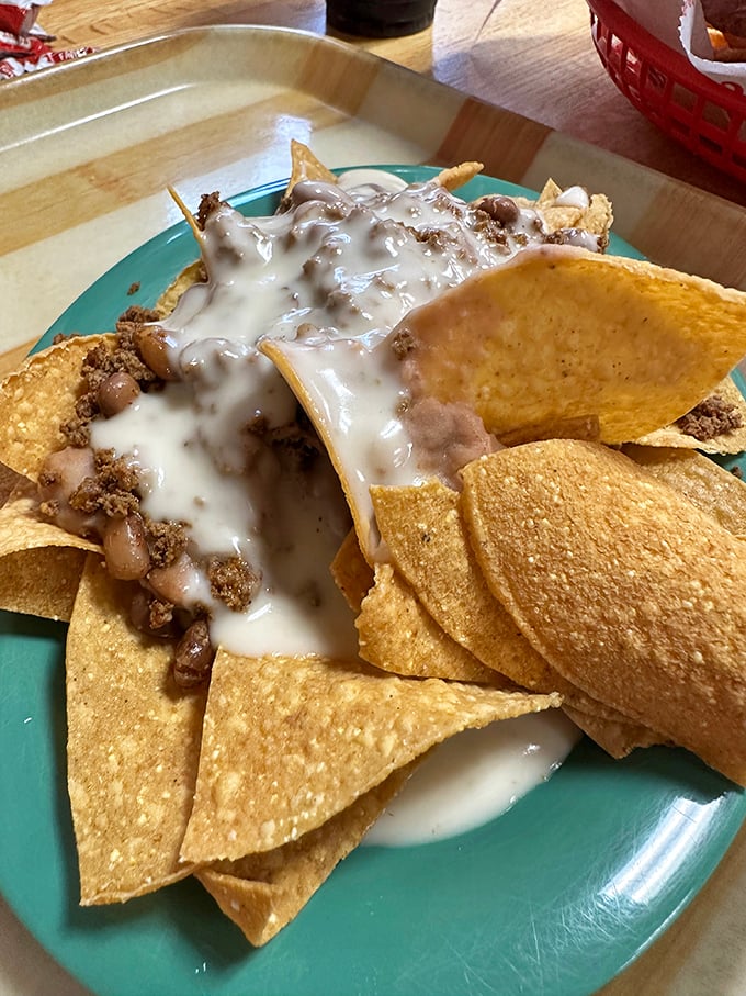 Behold the holy grail of nachos&mdash;where cheese sauce cascades over seasoned beef like a dairy waterfall of dreams.