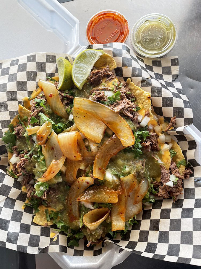 Nachos aren't just a snack here&mdash;they're an architectural masterpiece. That lime wedge isn't decoration; it's the perfect acid to cut through all that glorious richness.