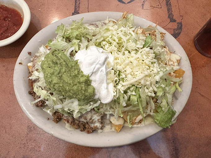 Layer upon glorious layer of crispy chips, seasoned beef, and fresh toppings&mdash;this isn't just a plate of nachos, it's an edible architecture masterpiece.