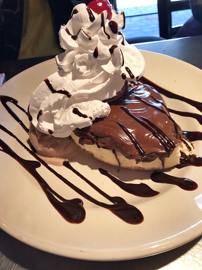 Nutella cheesecake arrives like a dessert superhero, cape of whipped cream billowing behind its chocolate-draped shoulders.