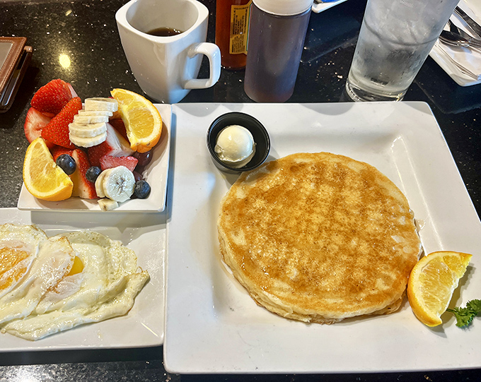 Pancakes so perfectly golden they deserve their own Instagram account, paired with nature's candy—fresh fruit that actually tastes like fruit.