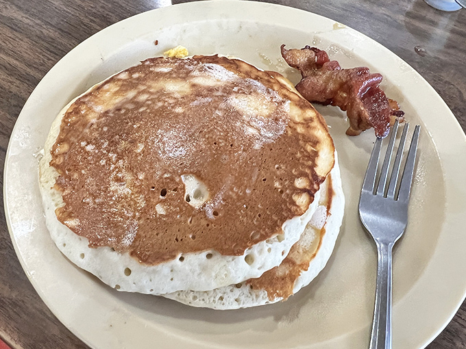 That golden-brown pancake with its perfectly crisp edges is the kind of simple perfection that makes you wonder why anyone bothers with fancy brunches.