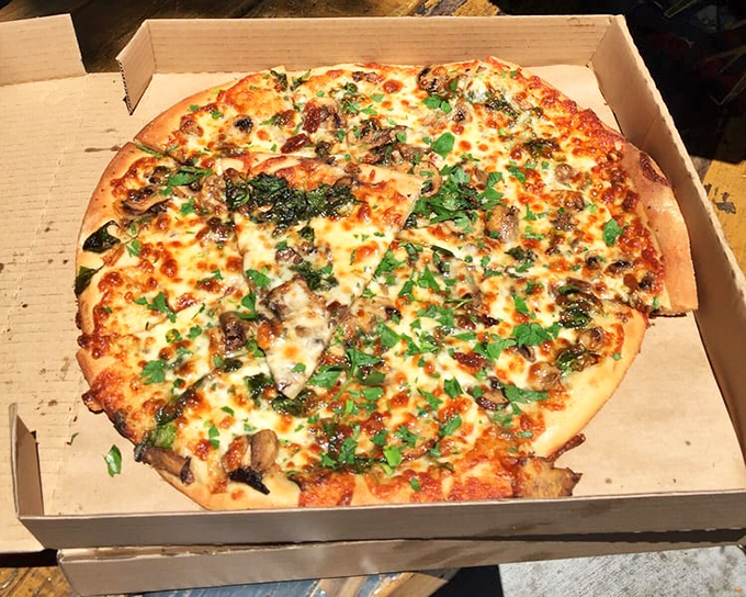 Pizza poetry in a cardboard box. The perfect distribution of toppings creates a masterpiece where every bite delivers maximum flavor.