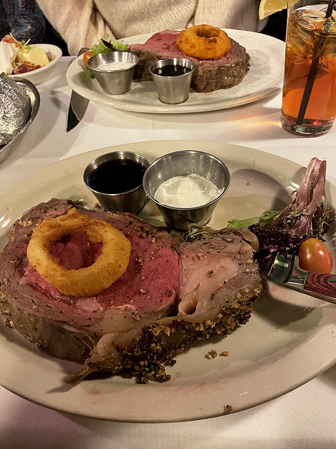 The prime rib arrives like royalty, crowned with that signature onion ring and flanked by its loyal subjects: horseradish cream and au jus.
