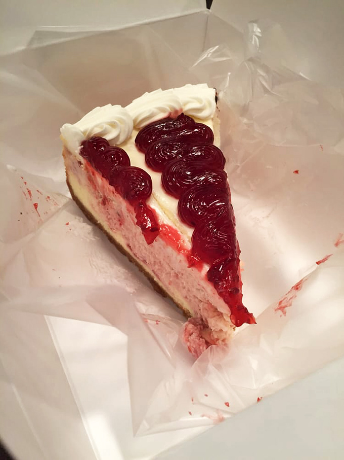 This raspberry cheesecake doesn't just have a swirl—it has a full-on raspberry revolution happening atop that creamy canvas.