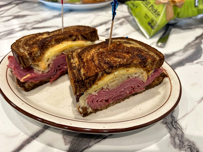 The Reuben in its natural habitat &ndash; perfectly grilled marble rye housing a harmonious marriage of corned beef, sauerkraut, and Swiss that would make New York proud.