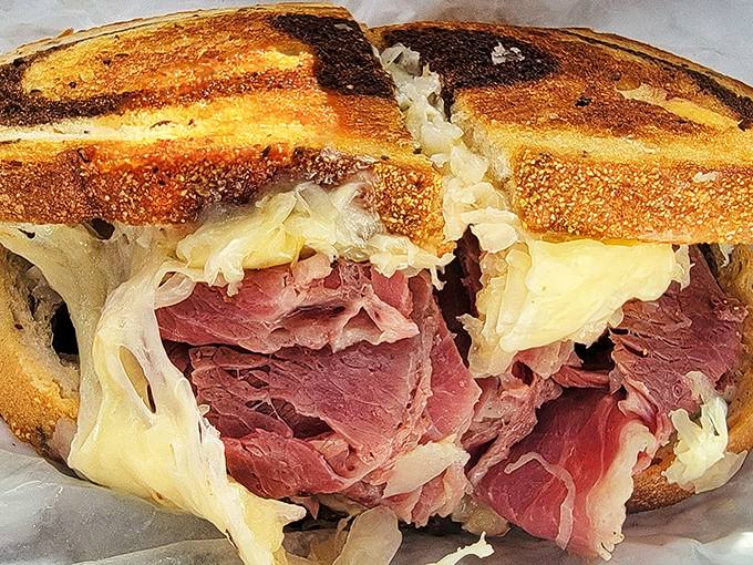 Behold the Reuben in its natural habitat &ndash; perfectly grilled marble rye embracing a mountain of corned beef, sauerkraut, and Swiss cheese in perfect harmony.