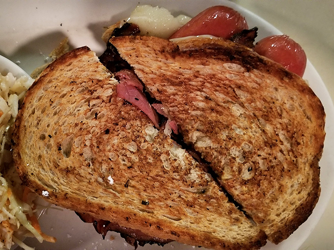 The Reuben in its natural habitat—perfectly grilled rye creating that symphony of crunch giving way to tender corned beef. This isn't a sandwich; it's architecture.