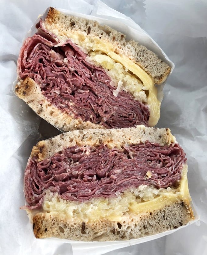 Behold the Reuben in all its stratospheric glory. Layers of corned beef so generous they require architectural support from perfectly grilled rye bread.