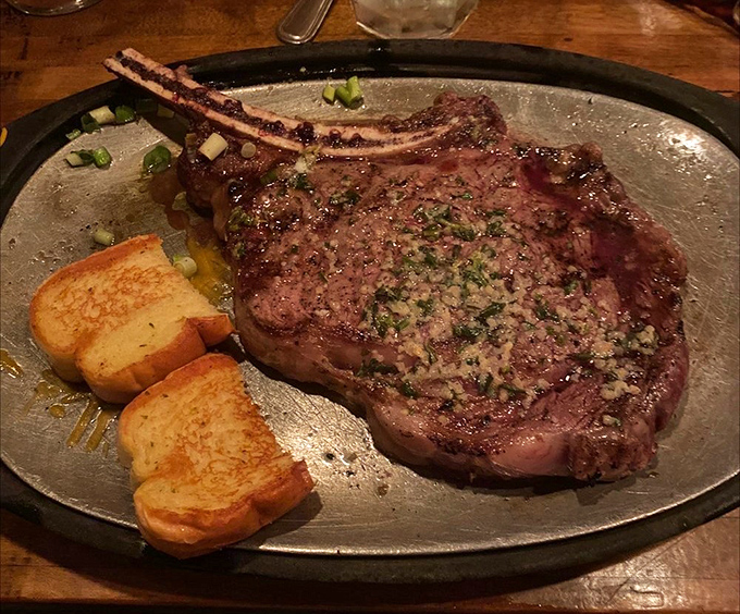 Behold the ribeye in its natural habitat&mdash;a sizzling metal plate. That garlic butter pooling around the edges isn't just delicious; it's performing a sacred duty.