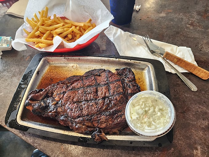 This isn't just a steak; it's a smoked ribeye manifesto on a metal tray. The beautifully charred exterior protects a pink, juicy interior that haunts carnivorous dreams.
