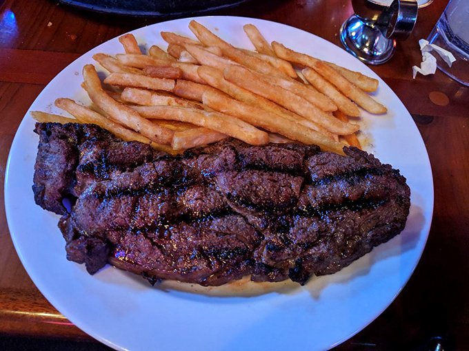 This ribeye isn't just a steak, it's a statement. The perfect char outside, tender pink inside, and those fries standing at attention like delicious soldiers.