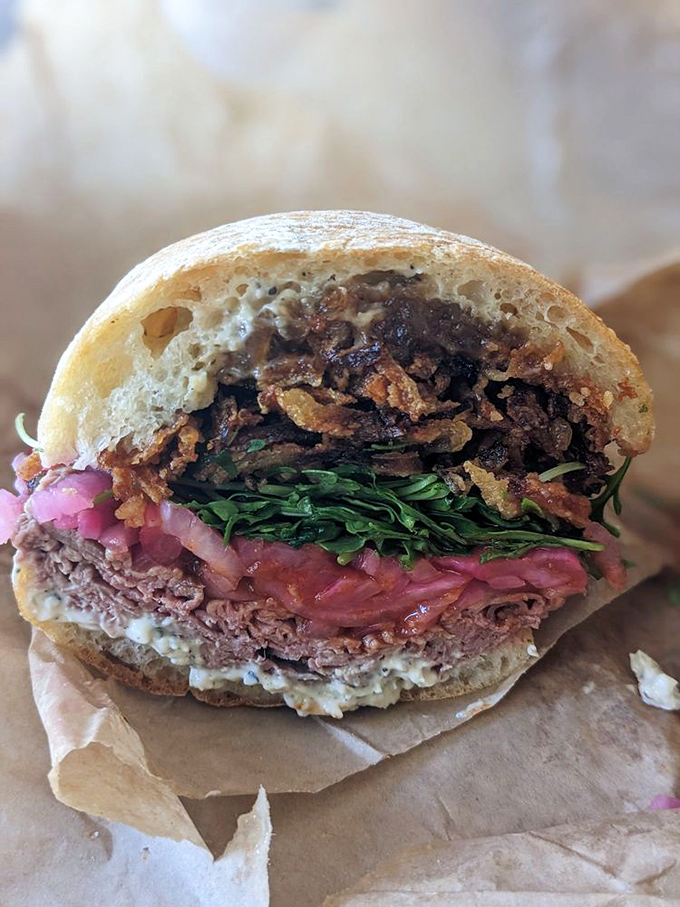 Behold the star attraction! Layers of roast beef, crispy onions, and greens create a masterpiece that demands to be photographed before devoured.