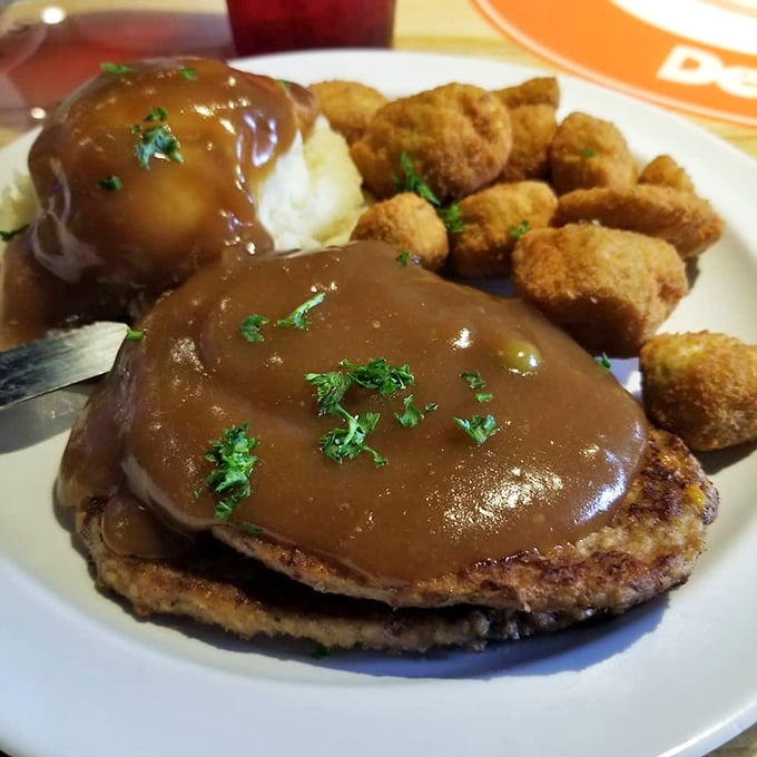 Behold the star attraction: Salisbury steak swimming in gravy that could make a vegetarian reconsider their life choices. Those golden-fried okra nuggets aren't just side characters.